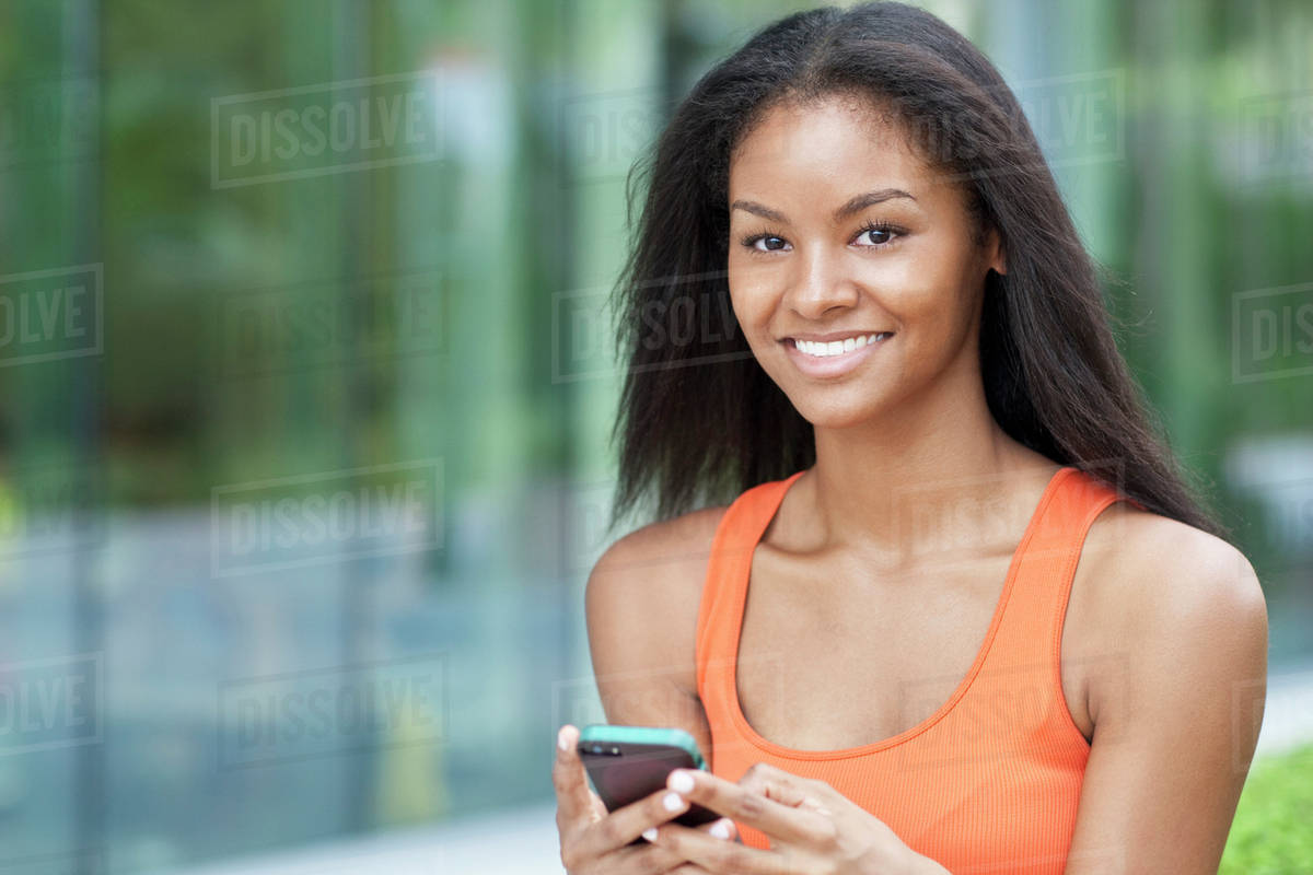 Black woman using cell phone outdoors - Stock Photo - Dissolve