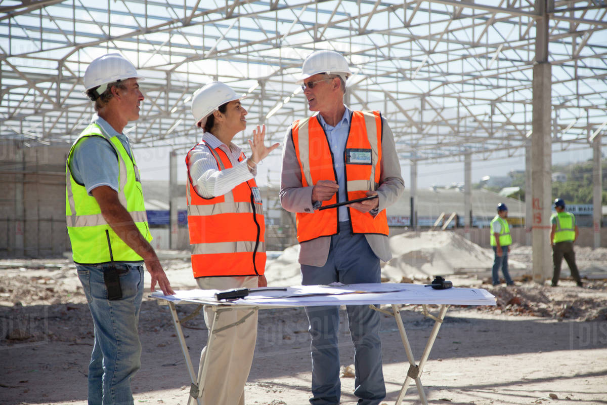 Architects talking at construction site - Stock Photo - Dissolve
