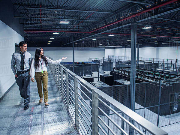 Businesswoman showing colleague server room from balcony - Royalty-free ...