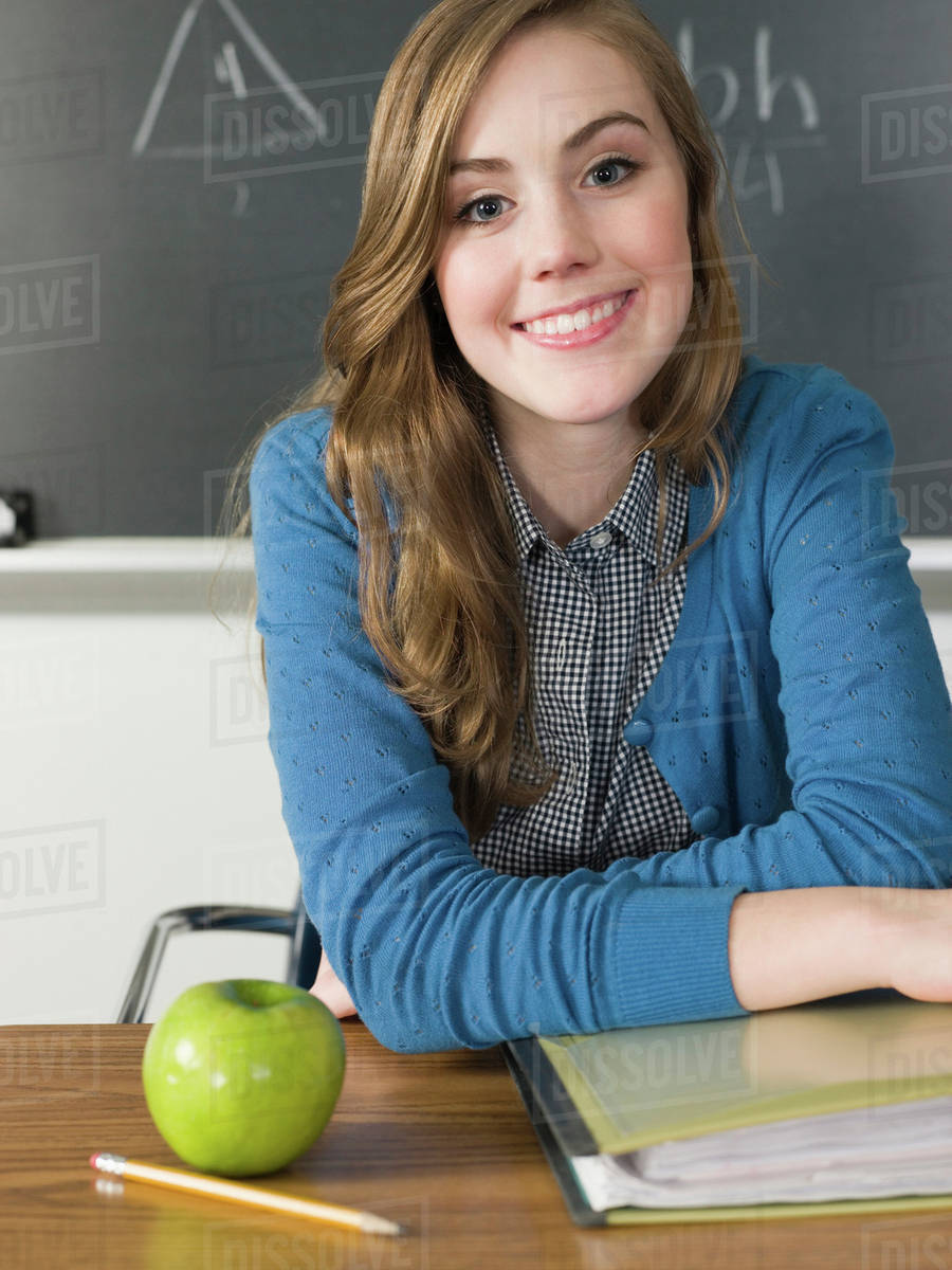 Student with apple smiling at desk in classroom - Royalty-free Stock ...