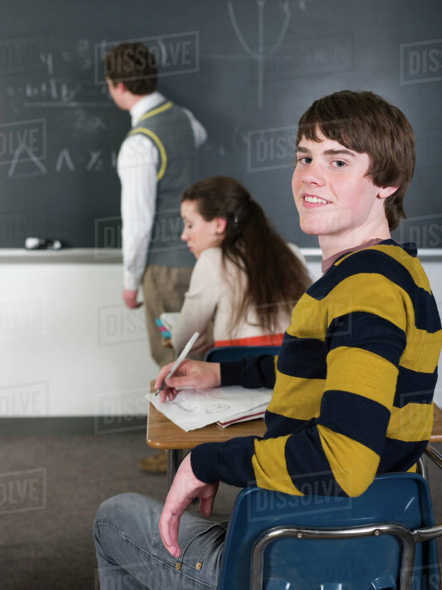 Student smiling at desk in classroom - Royalty-free Stock Photo | Dissolve