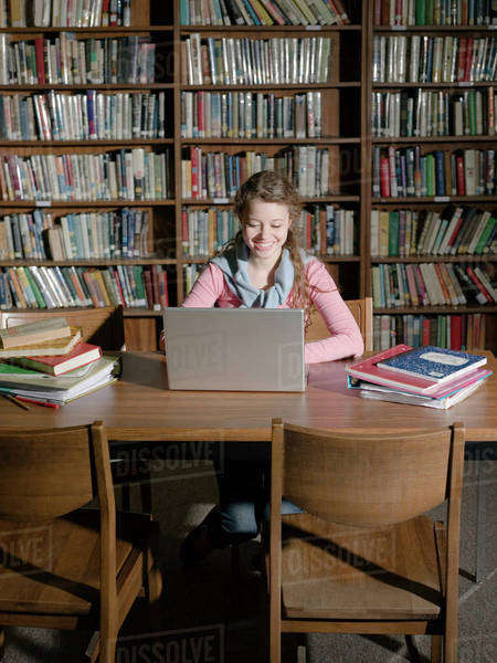 Student using laptop in library - Royalty-free Stock Photo | Dissolve