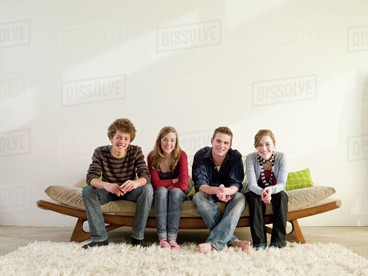 Friends sitting on modern sofa in living room - Royalty-free Stock ...