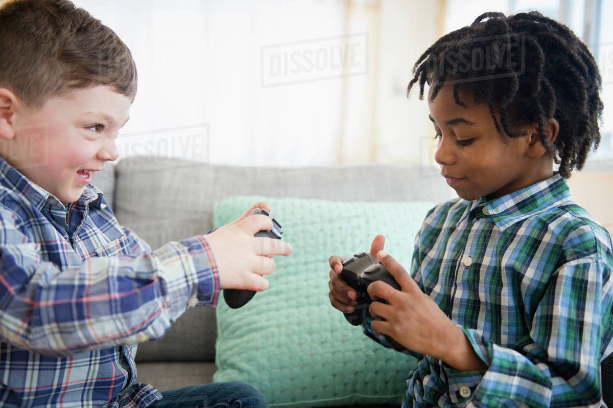 Boys playing video games on sofa - Royalty-free Stock Photo | Dissolve
