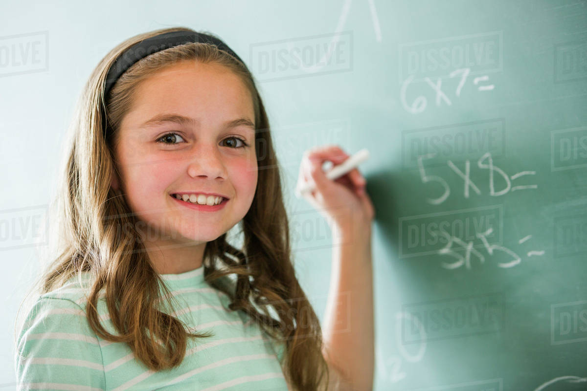Caucasian girl doing math problems on chalkboard - Royalty-free Stock ...