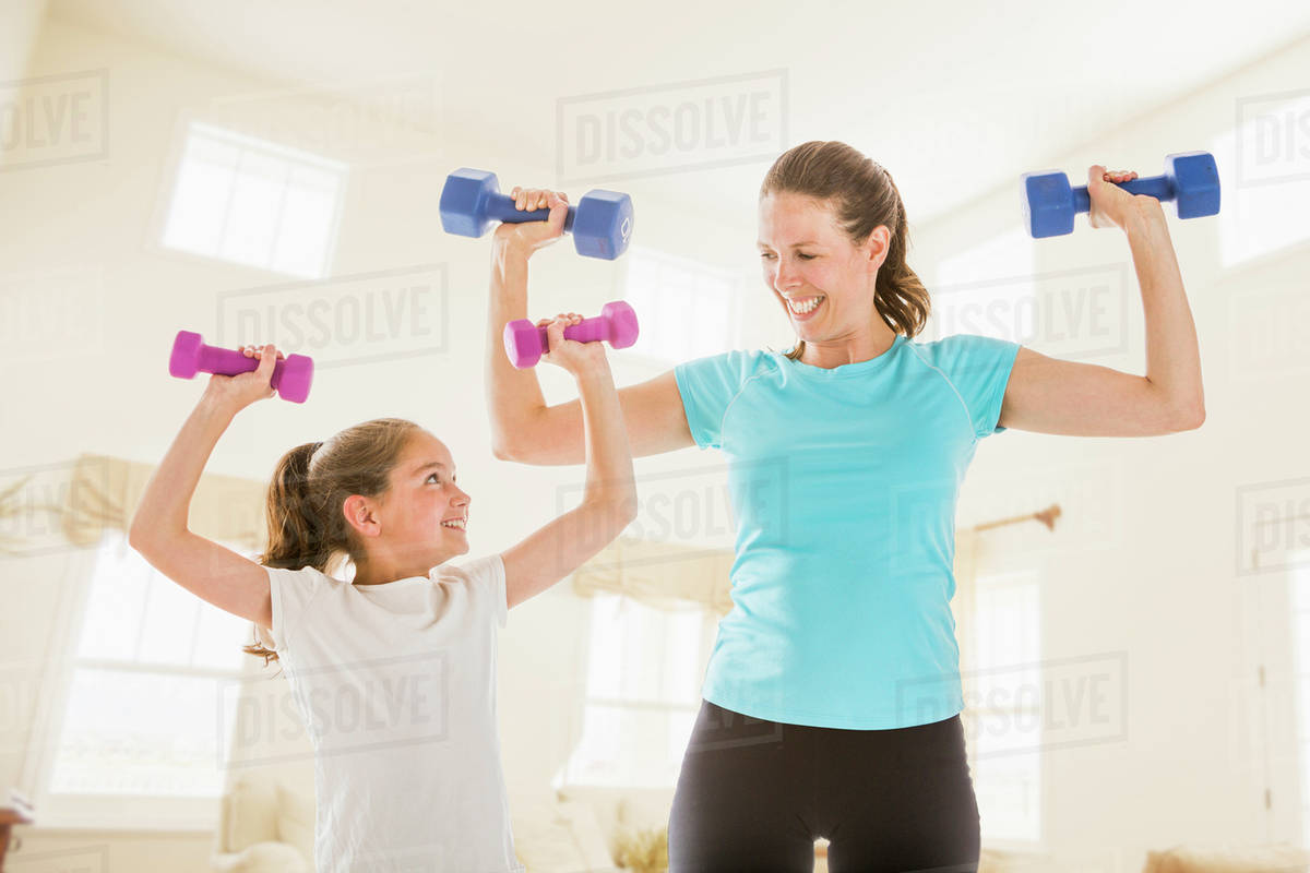 Caucasian mother and daughter lifting weights - Royalty-free Stock ...
