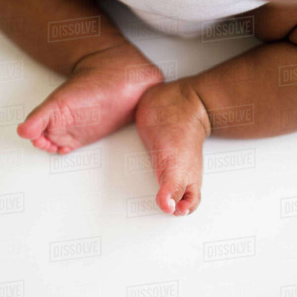 Mixed race baby girl's feet - Stock Photo - Dissolve