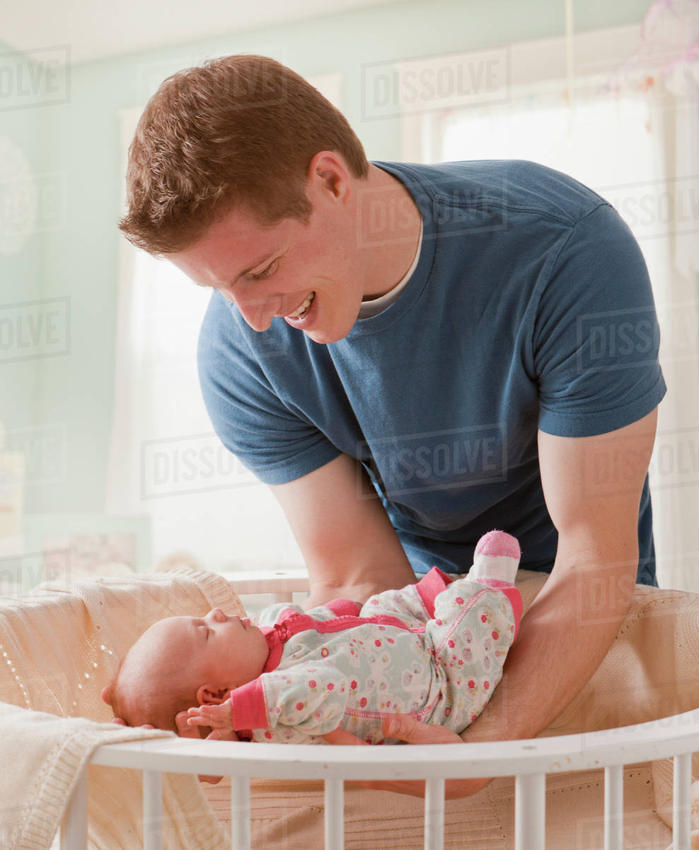 Caucasian father lifting baby girl from crib - Royalty-free Stock Photo ...