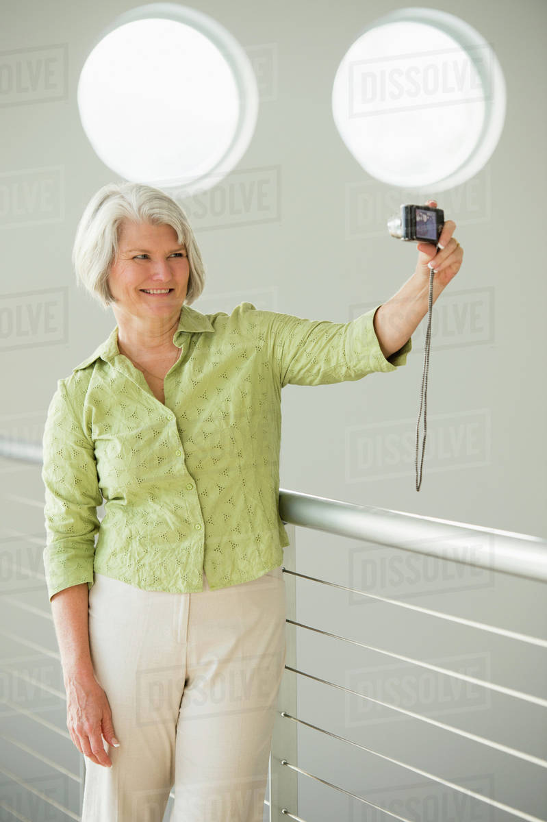 Caucasian woman taking digital self-portrait - Stock Photo - Dissolve