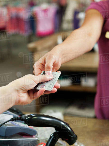 Woman handing over credit card in store - Royalty-free Stock Photo ...