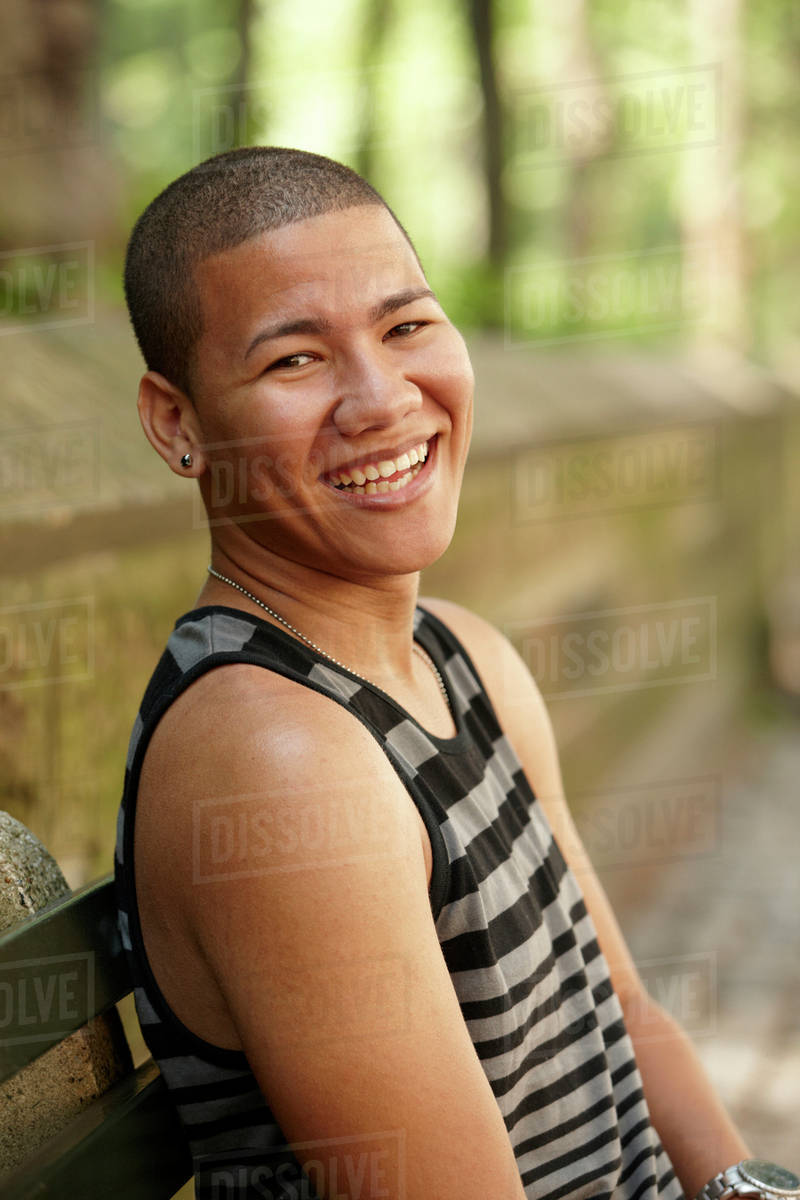 Smiling man sitting on bench outdoors - Royalty-free Stock Photo | Dissolve