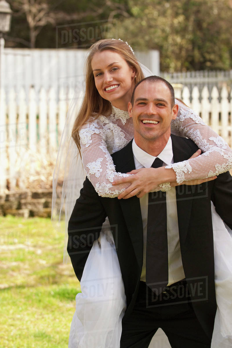 Caucasian groom carrying bride - Royalty-free Stock Photo | Dissolve