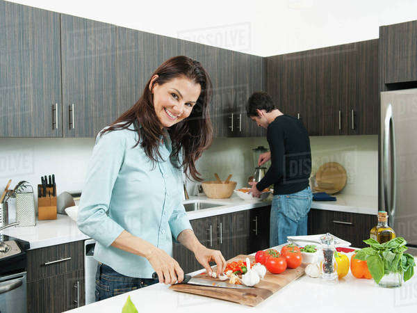 Couple making dinner together in kitchen - Royalty-free Stock Photo ...