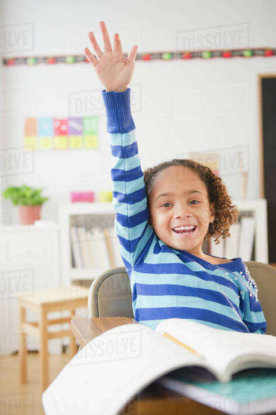 African American girl raising hand in classroom - Stock Photo - Dissolve