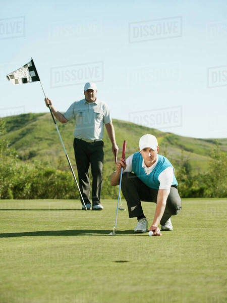 Caucasian golfer placing golf ball on course - Royalty-free Stock Photo ...