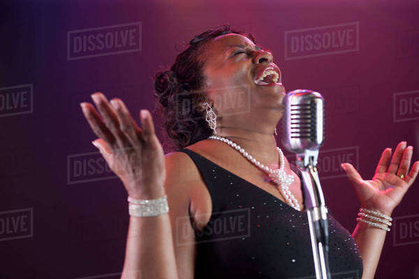 Black woman singing on stage - Stock Photo - Dissolve