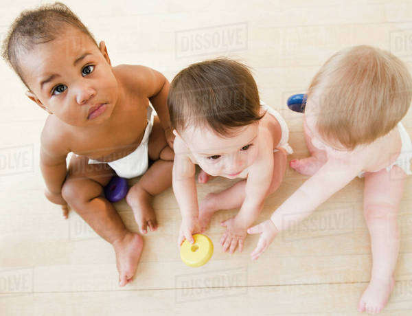 Babies playing together on floor - Royalty-free Stock Photo | Dissolve