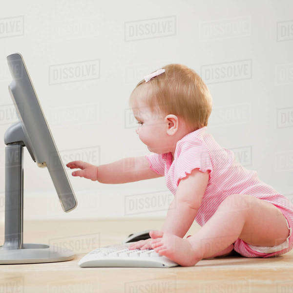 Caucasian baby playing with computer - Royalty-free Stock Photo | Dissolve