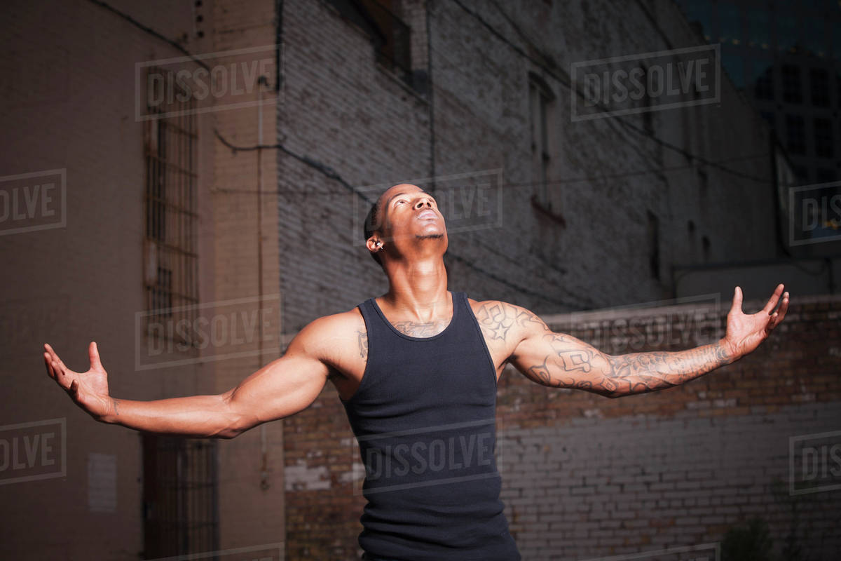 Black man standing outdoors with arms outstretched - Royalty-free Stock ...