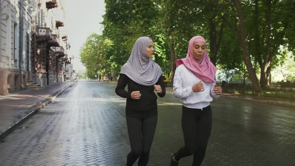 Two muslim models in sport clothes and colorful hijabs. They smiling ...