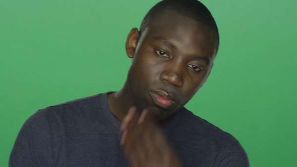 Young man looks sad and upset, on a green screen studio background ...