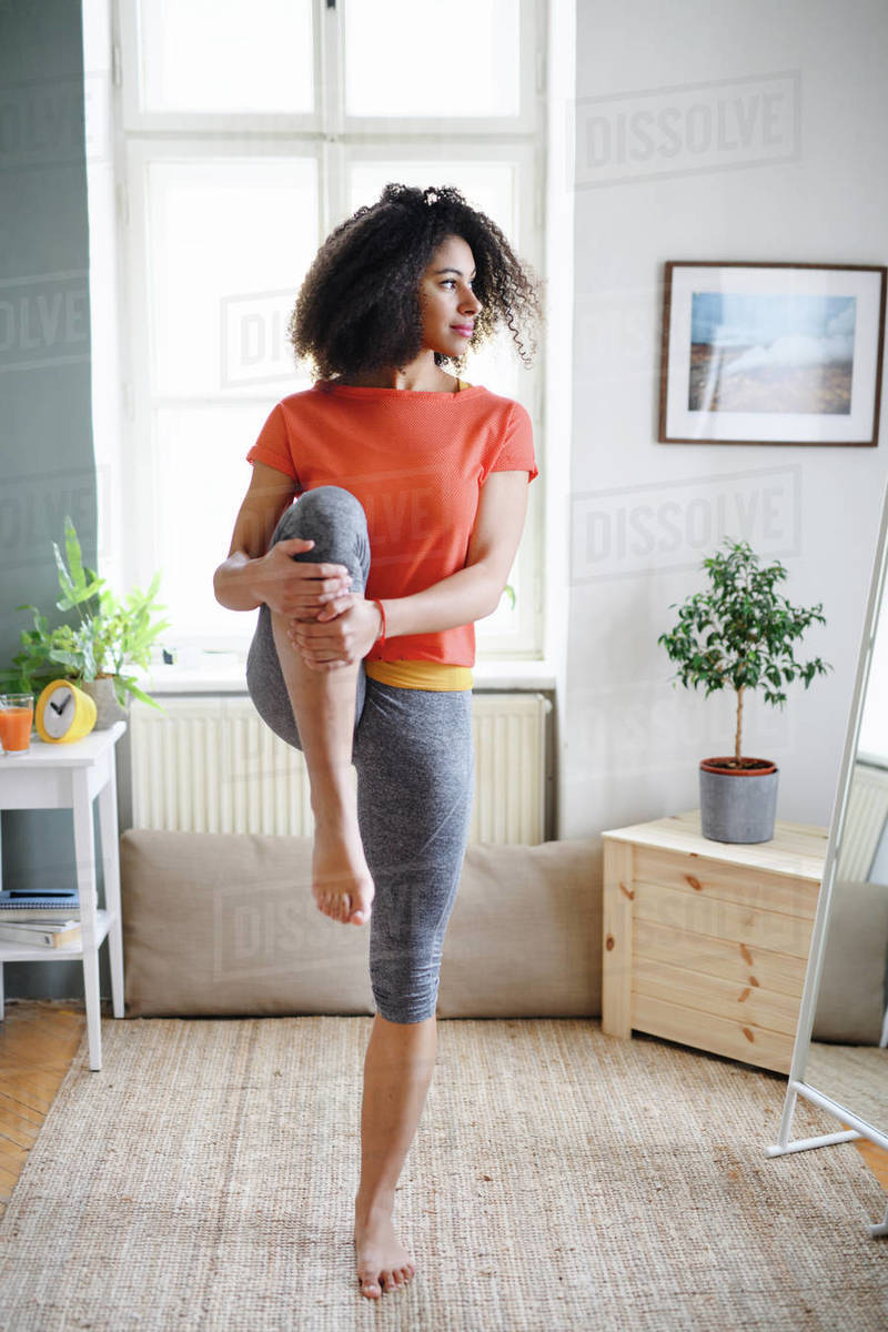 Happy young woman indoors at home, doing exercise. Sport concept ...