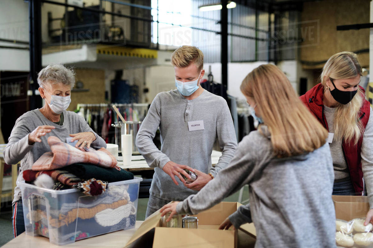 Group of volunteers working in community charity donation center, food ...