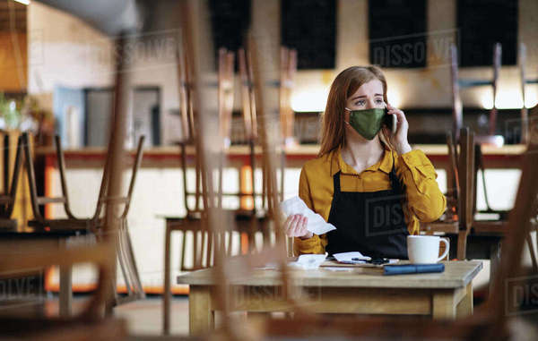 Frustrated owner sitting at table in closed cafe or coffee shop, small ...