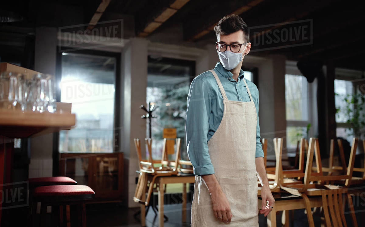 Frustrated waiter standing in closed cafe or coffee shop, small ...