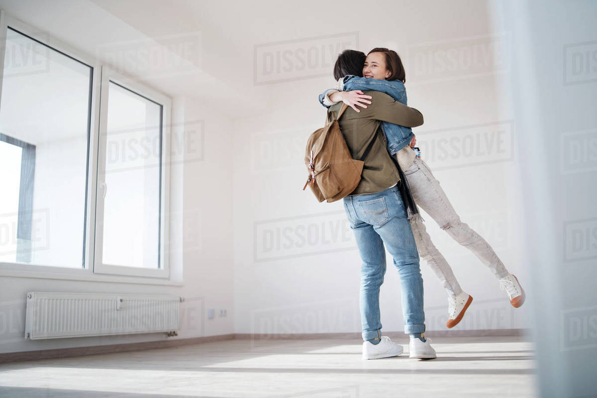 Happy young couple owners hugging in new flat, moving in, new home and ...