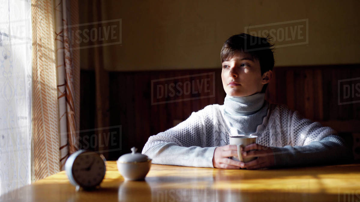 Sad poor sad small girl sitting at the table indoors at home, poverty ...