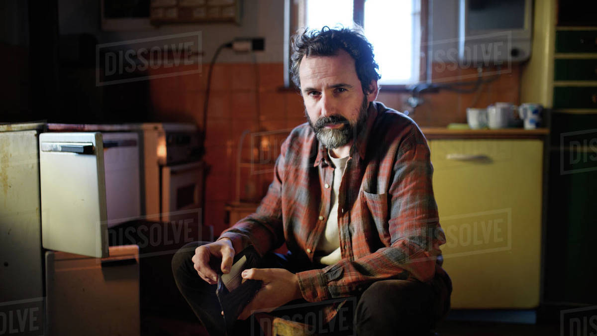 Portrait of poor mature man with empty wallet looking at camera indoors ...