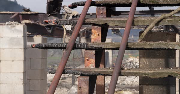 Close-up partially burned stairs and smoldering rubble in the aftermath ...