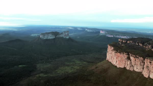 Aerial pan: Lush green valley among stunning mountains in Chapada ...