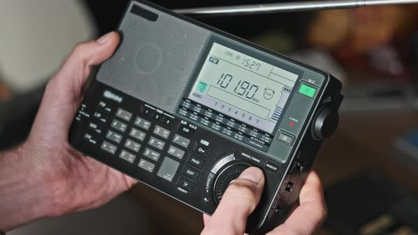 Man searching frequency of radio stations on modern radio with digital ...