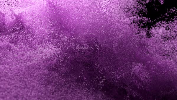 Violet particles fly on a black background. The wind blows away colored ...