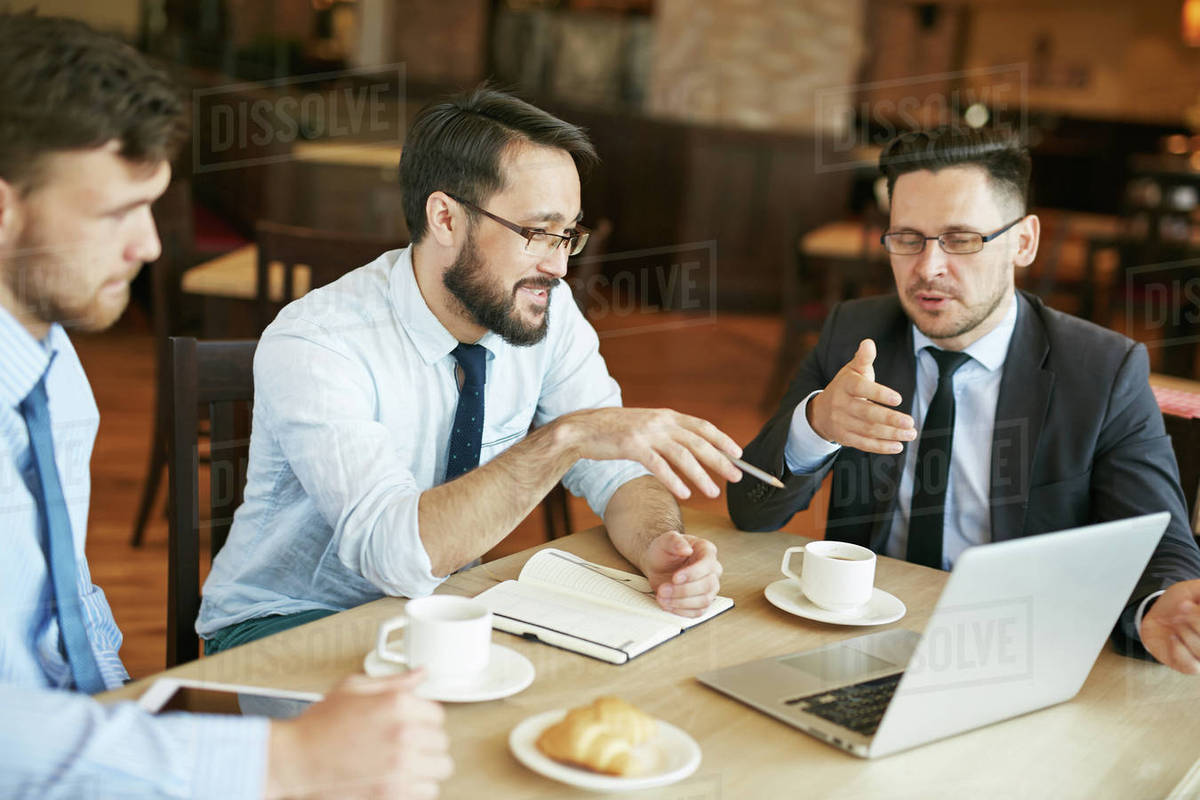 Two young intercultural business partners pointing at electronic data ...