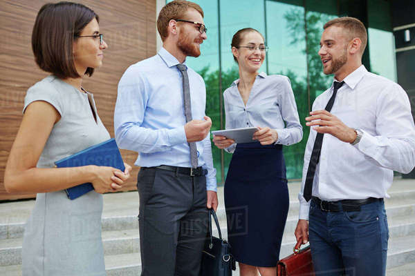 Four managers brainstorming and discussing business plans in urban ...