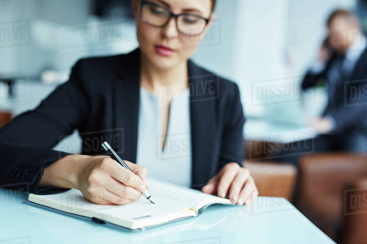 Secretary making notes in notebook - Royalty-free Stock Photo | Dissolve