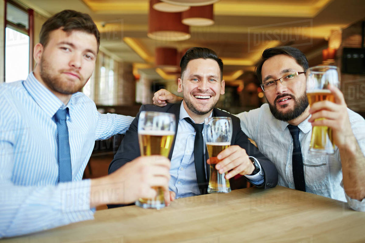 Happy businessmen toasting with lager in pub - Royalty-free Stock Photo ...