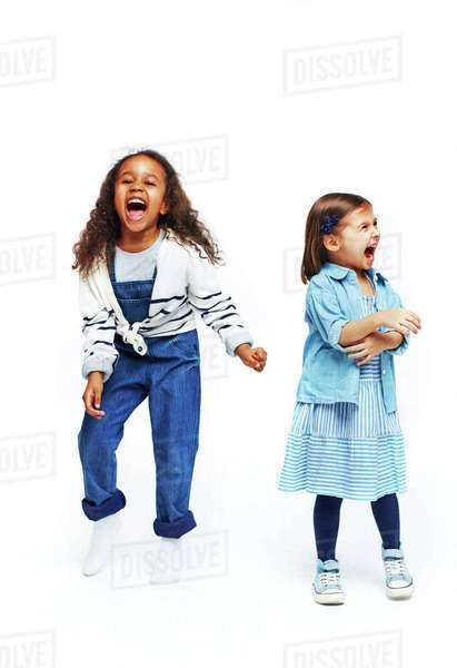 Two ecstatic girls in casualwear - Royalty-free Stock Photo | Dissolve