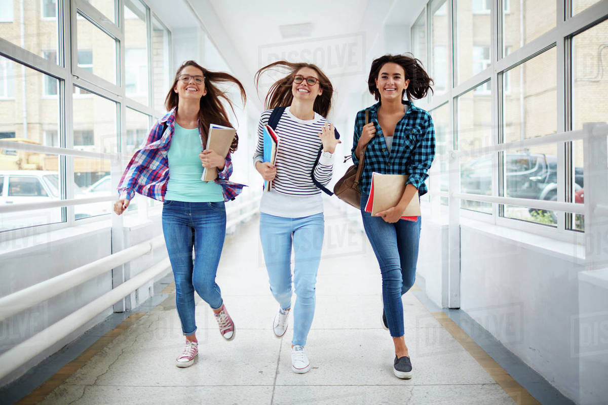 Three hurrying girls running for college class - Stock Photo - Dissolve