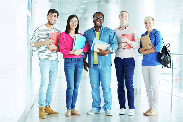 Portrait of happy group of classmates standing in corridor - Royalty ...