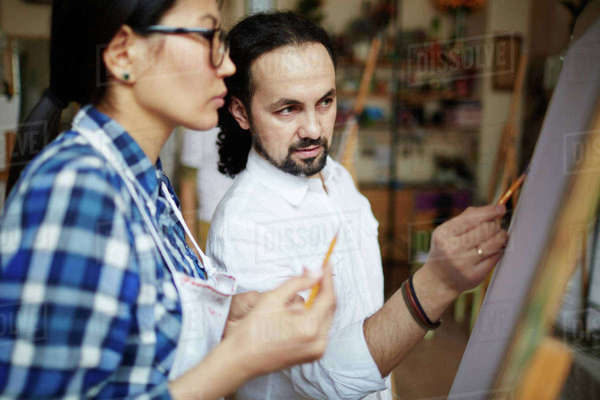 Teacher of arts explaining rules of drawing to her student - Stock ...