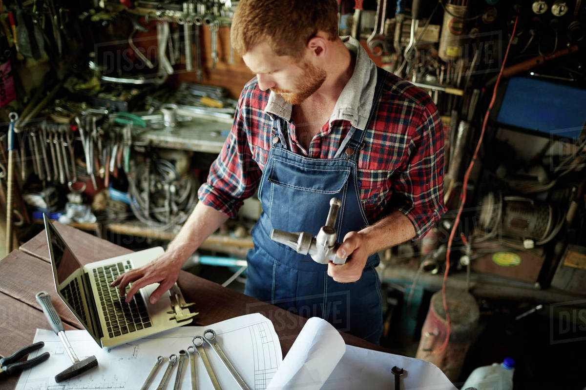 Auto mechanic using laptop in his workshop - Royalty-free Stock Photo ...