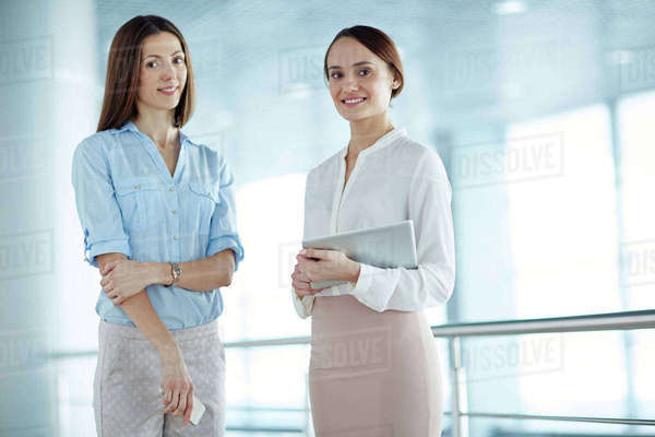 Portrait of two business ladies smiling at camera - Stock Photo - Dissolve