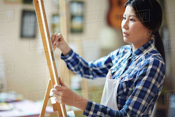 Serious female artist drawing on canvas - Royalty-free Stock Photo ...