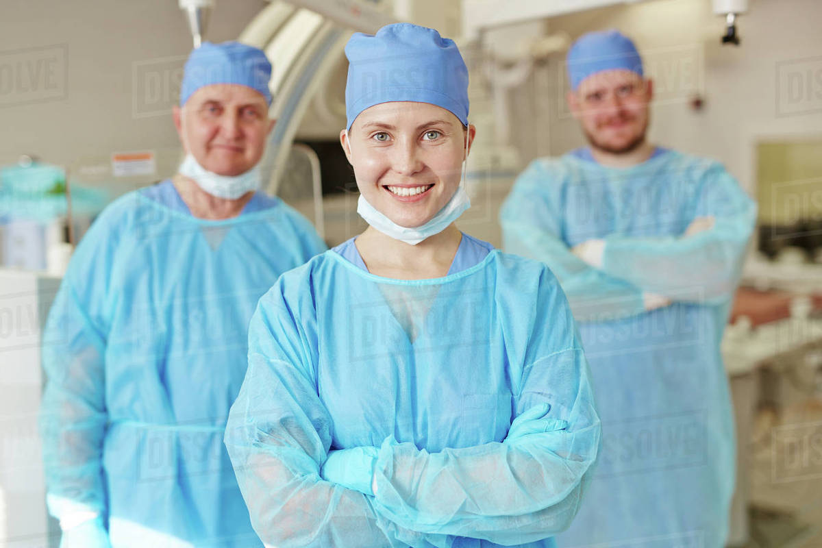 Surgeons standing in operating room and smiling at camera - Royalty ...
