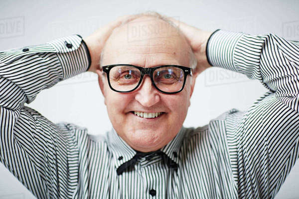 Portrait of a happy elderly man looking at camera wearing glasses ...