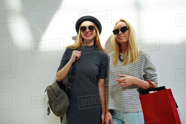 Stylish young women looking at camera with smiles - Stock Photo - Dissolve